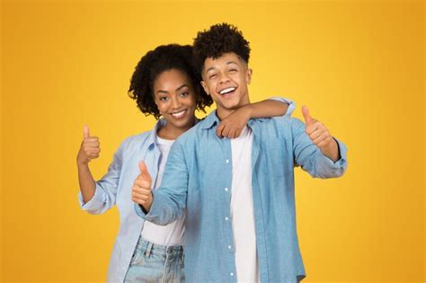 Premium Photo Two Joyful Young Adults Give Enthusiastic Thumbs Up To