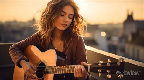 Adult Girl Plays Guitar On Building Roof At Sunset Young Woman Wall
