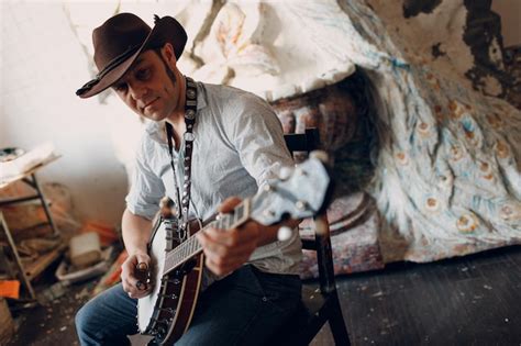 Premium Photo Male Musician Playing Banjo Sitting Chair Indoor