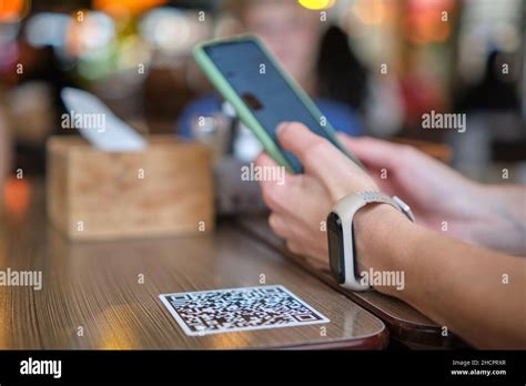 Closeup Of Guest Hand Ordering Meal In Restaurant While Scanning Qr Code With Mobile Phone For