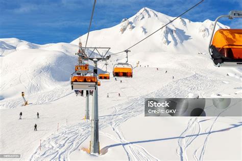 화창한 날에 힐랜드 알파인 산 겨울 리조트의 스키 리프트 로프 웨이 스키 체어 리프트 케이블 방식으로 스키와 스노우 보드를 즐길