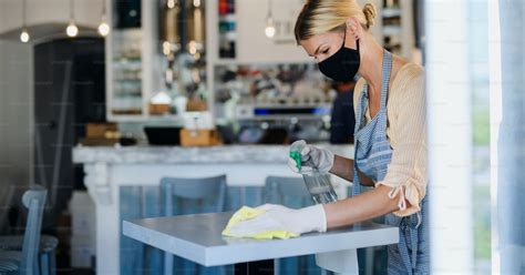 안면 마스크와 장갑을 끼고 테이블을 청소하고 소독하는 커피숍 여성 주인 사진 Unsplash의 가게 이미지
