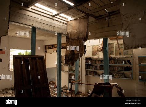 an abandoned school with broken wooden interior and rusty book shelves