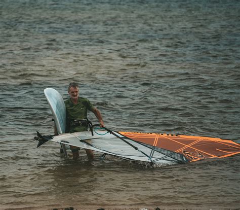 A Man Sitting On A Surfboard In The Water Photo Free Sea Image On