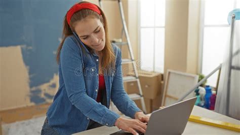 Woman Multitasking On Phone And Laptop In Modern Home During Renovation Showing Busy Lifestyle