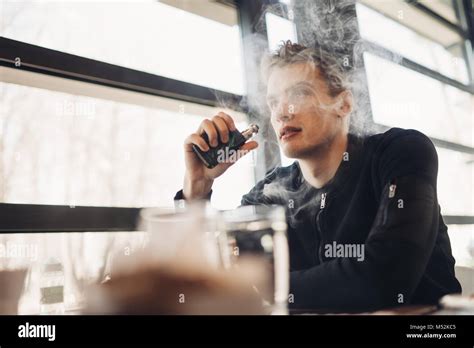 Young Man Vaping In Closed Public Space Smoking Electronic Cigarette In