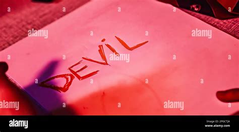 A Close Up Shot Of A Paper With The Word Devil Written In Cursive