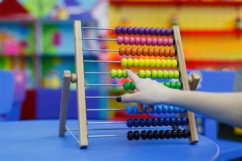 Premium Photo Closeup Of Female Hand Calculating On Wooden Abacus For