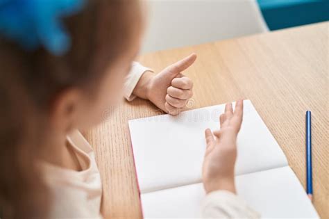 Adorable Caucasian Girl Doing Homework Sitting On Notebook At Street