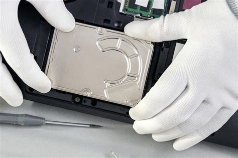 Premium Photo Technician Hands Removing An Old Mechanical Hard Disk From A Laptop Top View