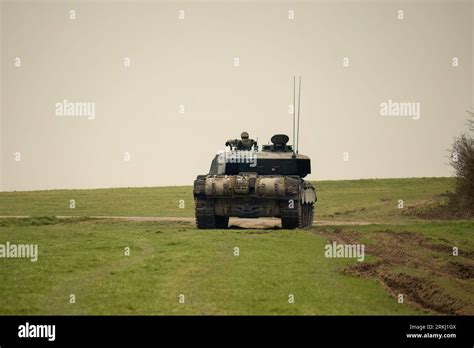 Two Men In Military Fatigues Riding On An Army Vehicle Navigating