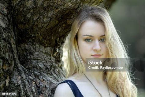 캐주얼 편안한 머리와 어깨 초상화 의 예쁜 금발 대학 학생 미소와 나무 아래에서 카메라를 보고 고요한 장면에 대한 스톡 사진 및 기타 이미지 Istock