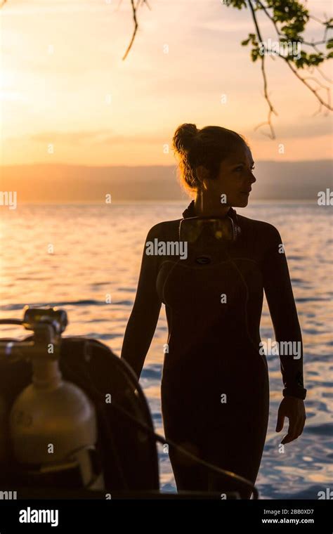 Female Scuba Diving Instructor Wearing A Wet Suit Standing Next To A