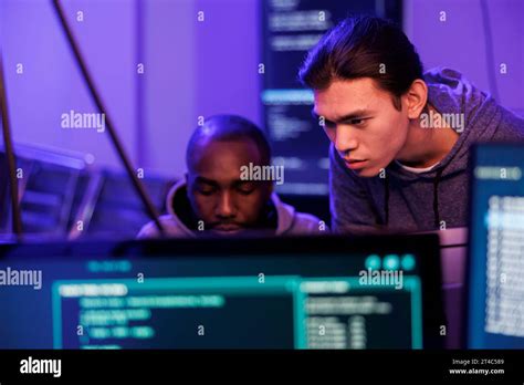 Hackers Analyzing And Discussing Malicious Code On Computer Screen