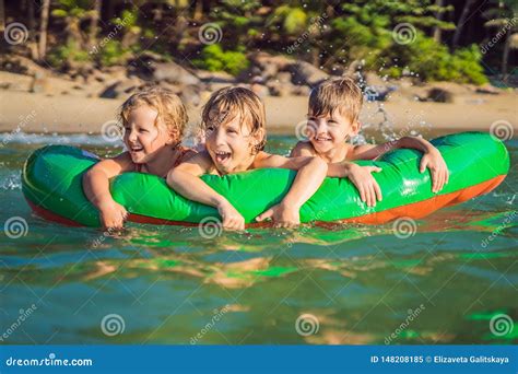 Barn Simmar I Havet P En Uppblsbar Madrass Och Har Roligt