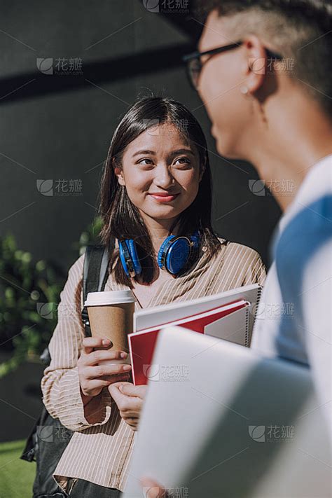 美丽的女性亚洲学生与她的朋友聊天