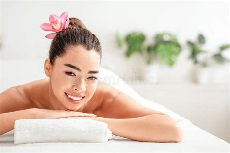 Beautiful Asian Woman Lying On Table In Spa Salon Waiting For Massage