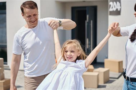 Mother And Father Play With Their Daughter In The Yard Stock Image