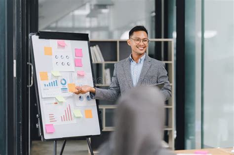 Confident Businessman Leading A Meeting Engaging With Colleagues While Presenting Data Charts