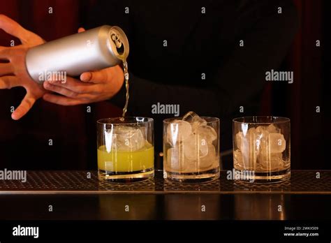 Bartender Pouring Energy Drink Into Glass At Counter In Bar Closeup
