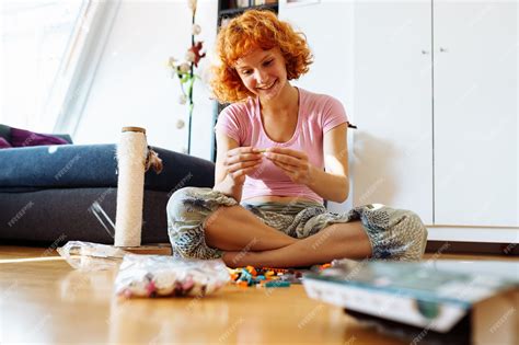 Premium Photo Teenage Girl Assembles Construction Set According To Instructions Sitting On