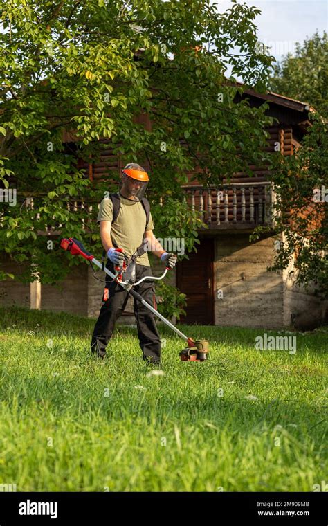 Landscape Maintenance Concept Man Cutting Grass In Yard By Using