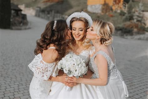 Premium Photo Stylish Bridesmaids Have Fun With The Bride In Nature And Pose And Kiss The Bride