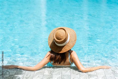Rear View Of Attractive Asian Woman In Bikini And Straw Hat Relaxing In