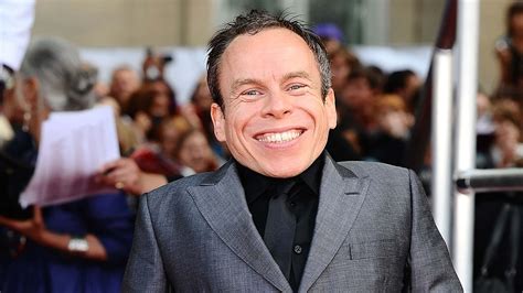 Download Warwick Davis Smiling In A Close Up Portrait Wallpaper