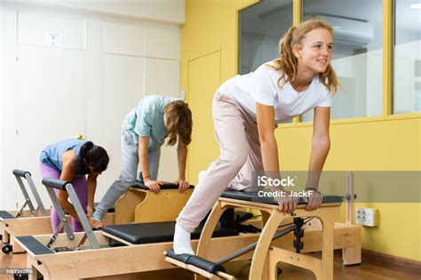 피트니스 스튜디오에서 개혁가에 대한 필라테스 운동을 수행하는 어린 소년과 소녀 12 13세에 대한 스톡 사진 및 기타 이미지 12 13세 14 15 살 3 명