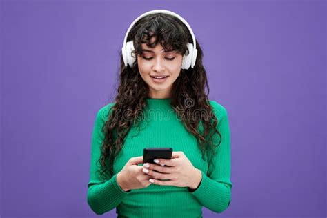 pretty girl with dark long wavy hair scrolling through playlist in