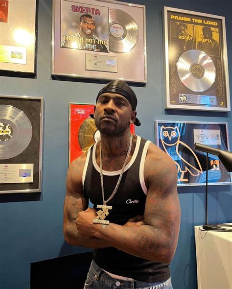 A Man With His Arms Crossed Standing In Front Of Records And Cds On The