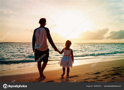 Father And Daughter Walking On Beach