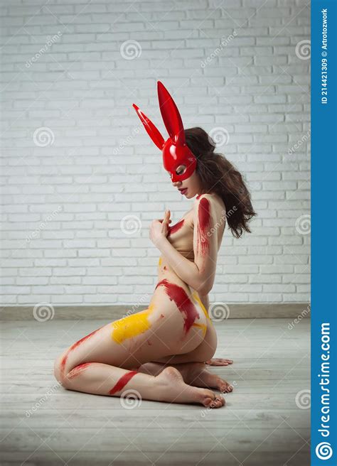 A Naked Woman In A Red Rabbit Mask Poses Against A Brick White Wall Stock Image Image Of