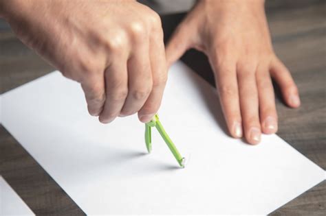 Premium Photo A Man Taking Notes With A Caliper On Paper