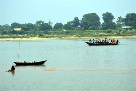 A Fisherman Catching Fish In The River And A Boat Carrying Passengers