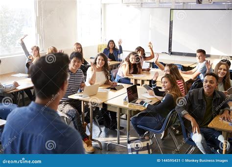 Rear View Of Male High School Teacher Standing At Front Of Class Teaching Lesson Stock Image