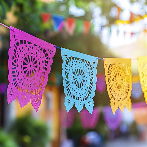Colorful Mexican Paper Cuttings Hanging Against Blur Road And Building