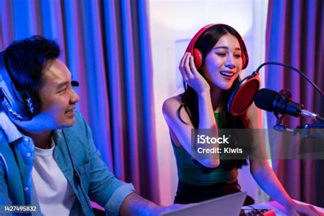 아시아 오디오 Dj 남자와 여자가 마이크에 마이크를 대고 방송에 나선다 젊은 아름다운 여성과 남성 블로거 영향력있는 사람이 헤드폰을 착용하고 스튜디오에서 라디오를위한 아침