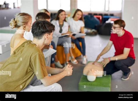 Cpr Class With Male Instructor Speaking And Demonstrating Help Giving Lessons Of First Aid