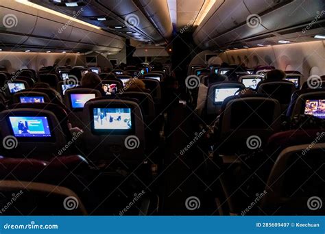Passenger Enjoying Inflight Entertainment In Economy Class With Lights
