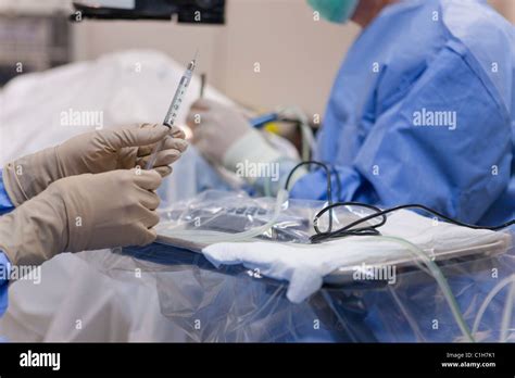 Surgical Technologist Passing Sterile Intraocular Irrigating Solution