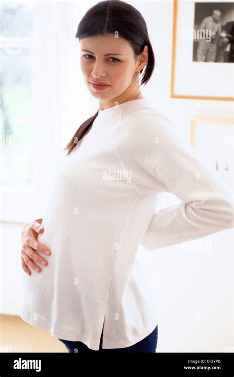 Profile Of Heavily Pregnant Female Brunette Hair Off Face Wearing White