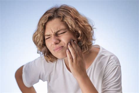 Woman Holding Jaw In Pain With Pained Expression From Tooth Or Gum