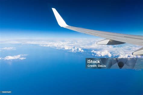 승객 창에서 푸른 하늘 아래 높은 고도에서 구름 위를 비행 하는 비행기의 날개의 보기 유럽을 통해 비행 구름을 통해 푸른 하늘에 비행 제트 비행기 날개의 보기 가리기에 대한