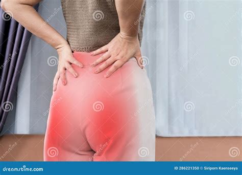 Woman Suffering From Lower Back And Buttock Pain Spreading To Down Leg