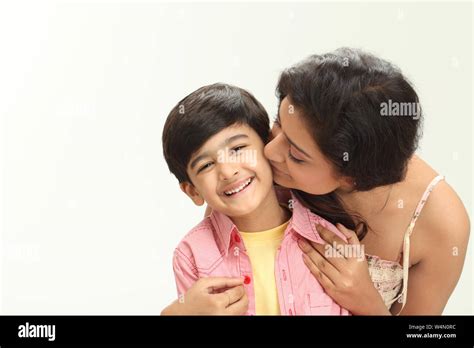 Woman Kissing Her Son On Cheek Stock Photo Alamy