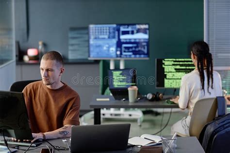 Calm Male Programmer Coding On Computer Working With Colleagues In It Company Office Stock Image