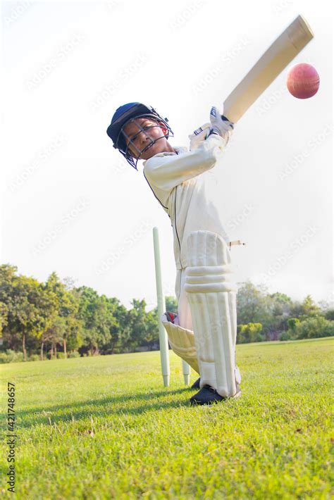 Young Boy Batting In Protective Gear During A Cricket Stock Foto
