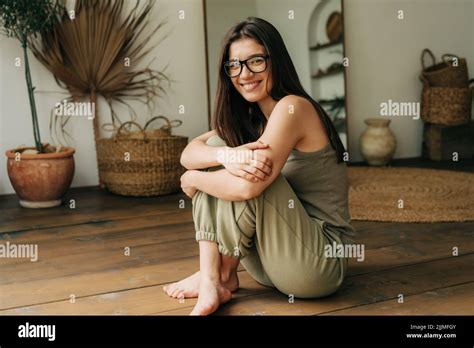 Une Jeune Fille Brune De Vingt Ans En Lunettes Est Assise Pattes Crois Es Sur Le Sol Et Sourit
